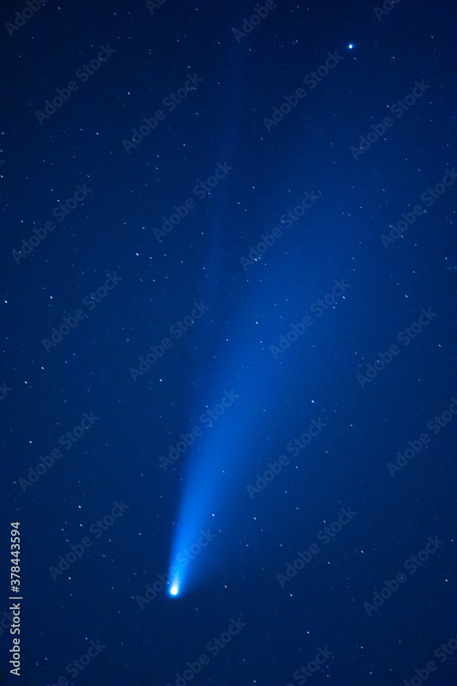 Trace of a comet or shooting star in a blue starry sky with stars in ...
