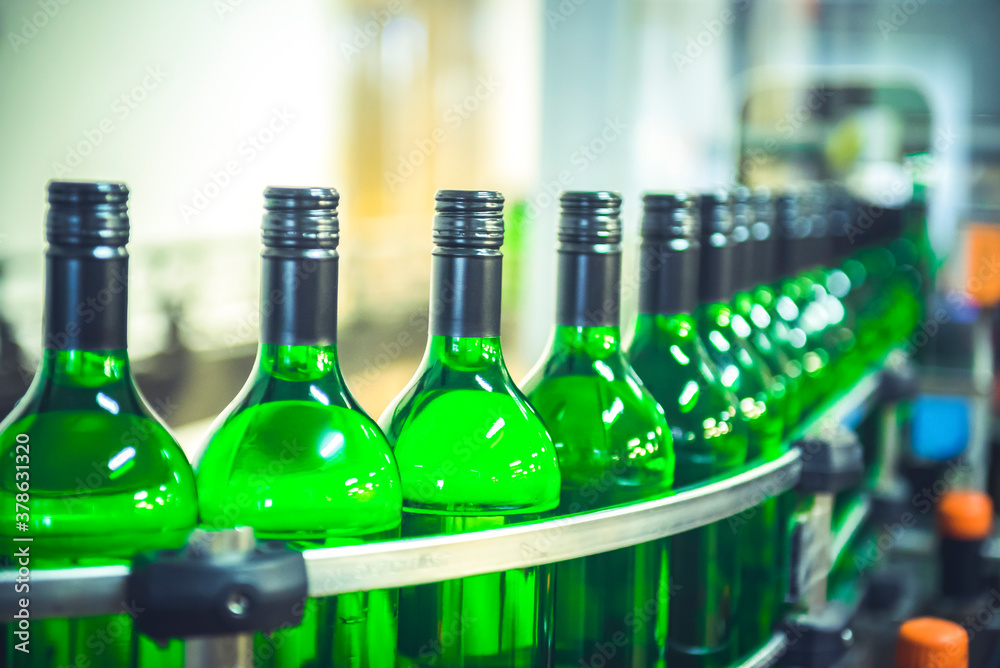 Beer or wine bottles on the conveyor belt. Bottling alkoholic drink ...