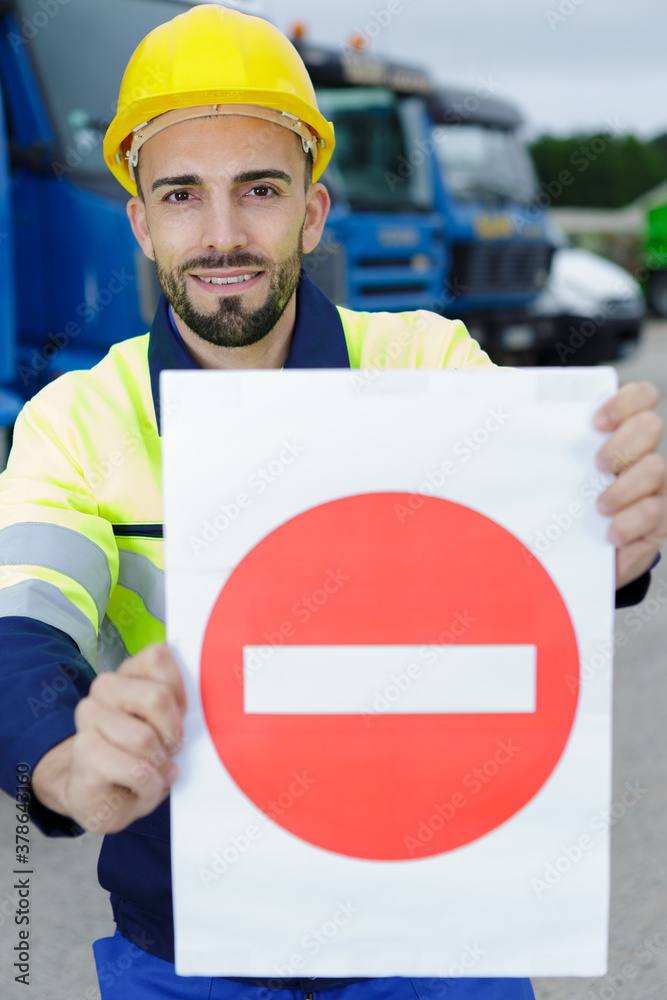 worker holding no entry sign Stock Photo | Adobe Stock