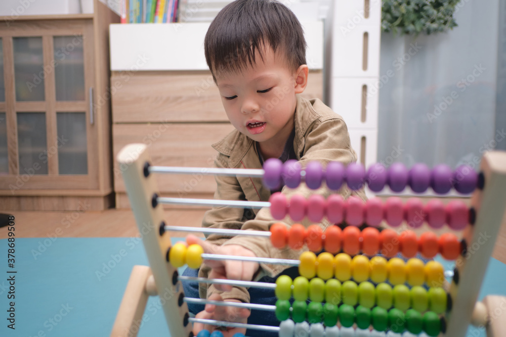 Cute little asian kindergarten 4 years old boy sitting on floor using ...