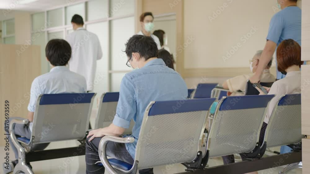 Busy hospital lobby with busy nurse, older patient on wheelchair, rear ...