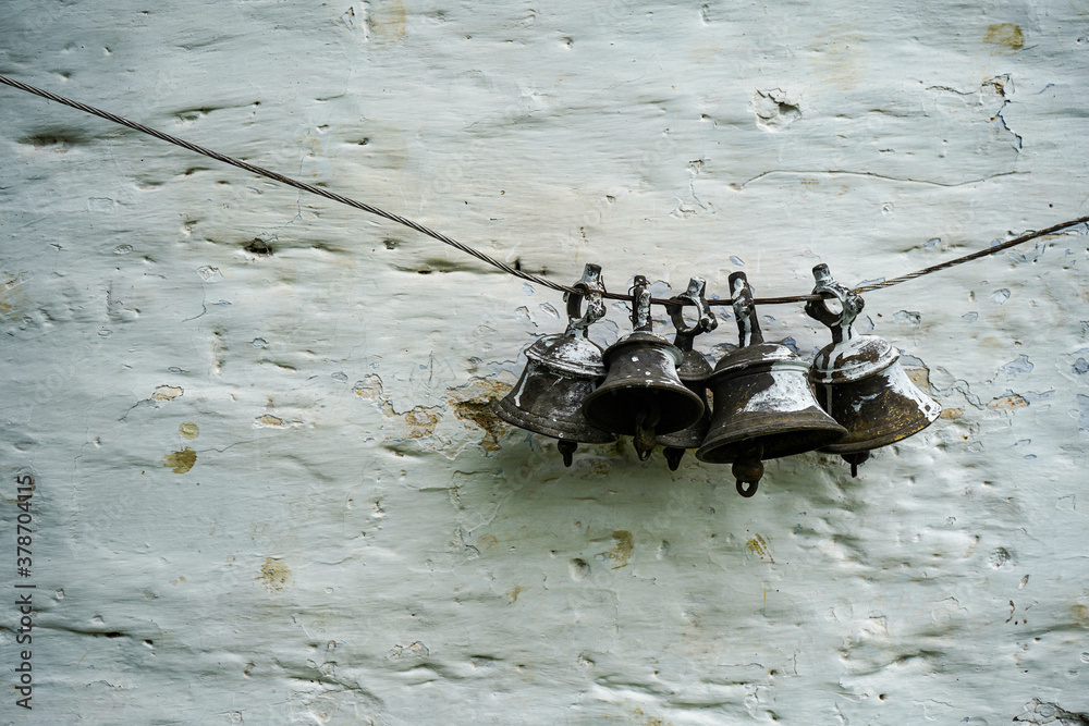 old vintage bells hanging on a white wall temple in India Stock Photo ...