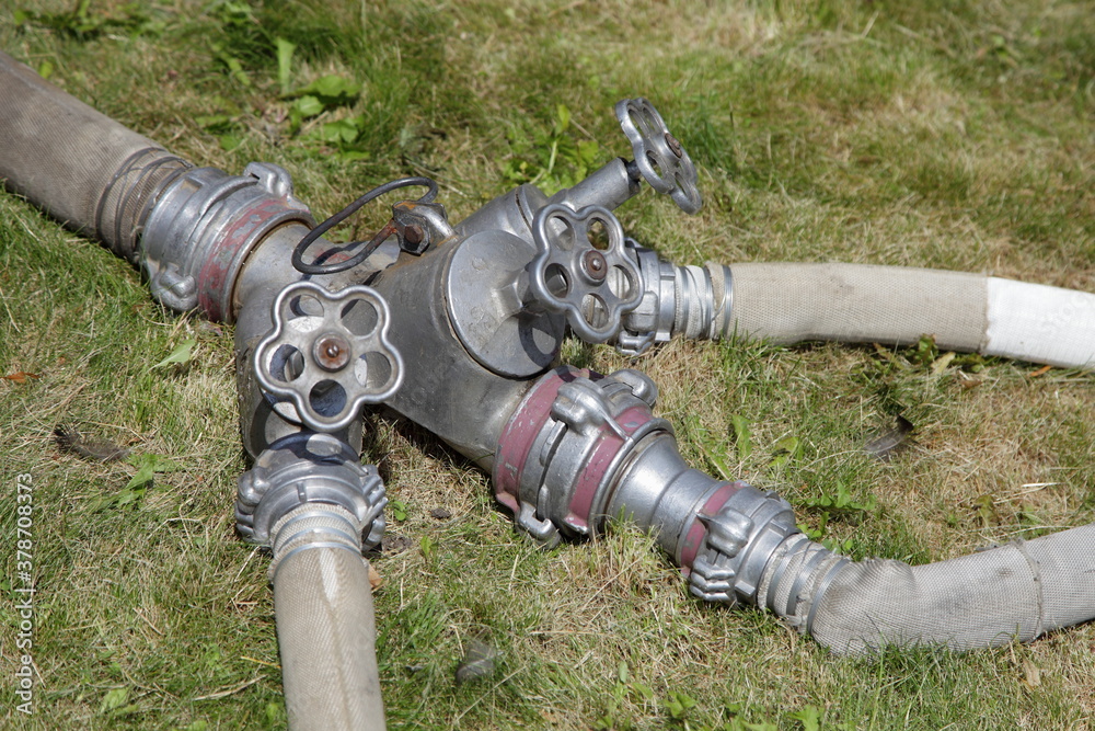 Fire hose tee close up, 3-way water distributor on grass outdoor ...