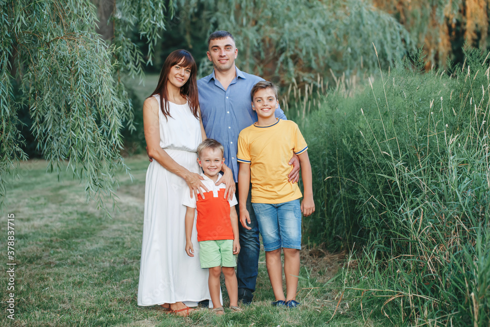 Beautiful happy Caucasian family of four people in park on summer day ...