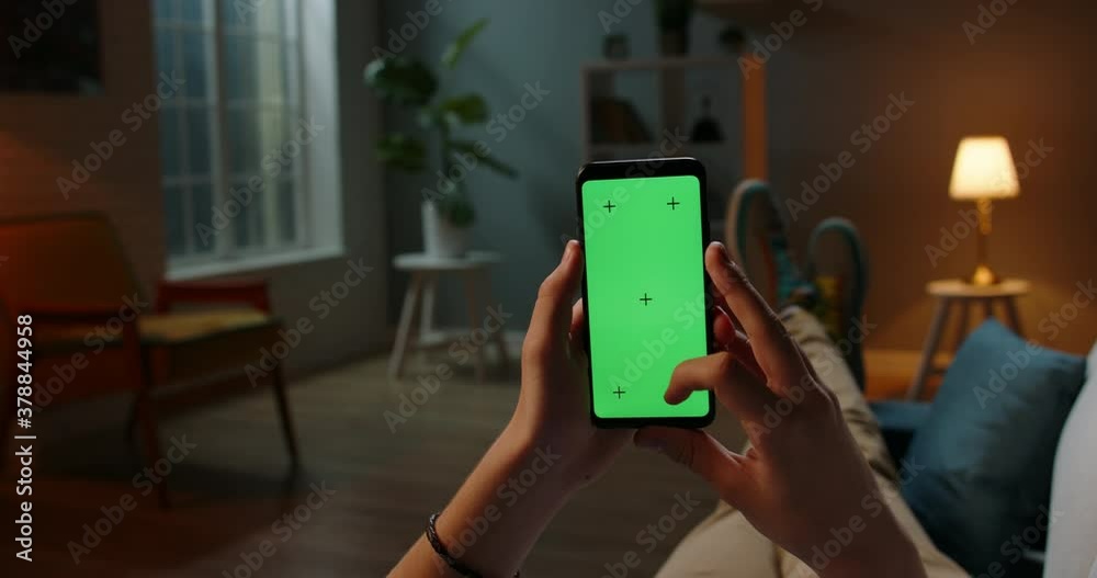 Vídeo do Stock: Man lying on couch using smartphone with chroma key green screen at night ...