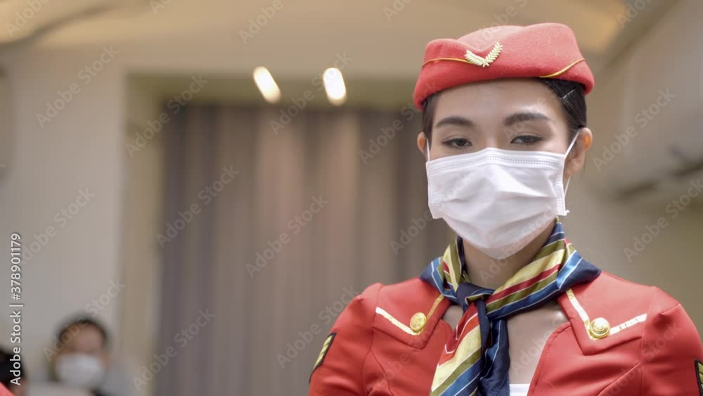 Asian woman flight attendant or cabin crew is wearing face mask cover ...