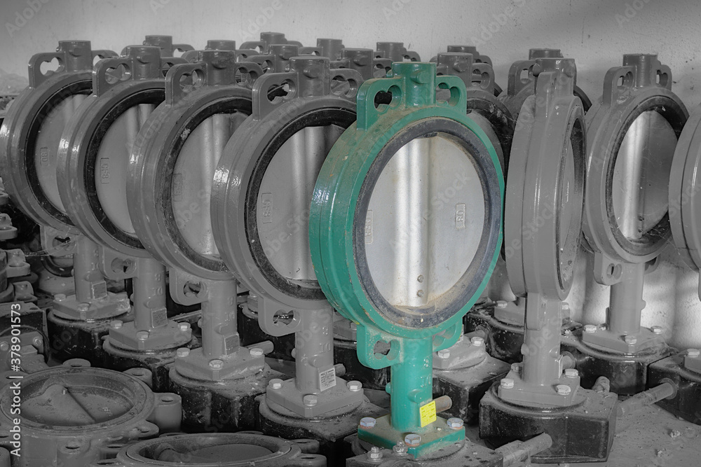 Sets of old stocked butterfly valves stored inside a warehouse facility ...