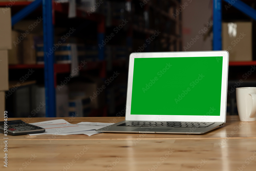 Computer with green screen display in warehouse storage room . Delivery ...