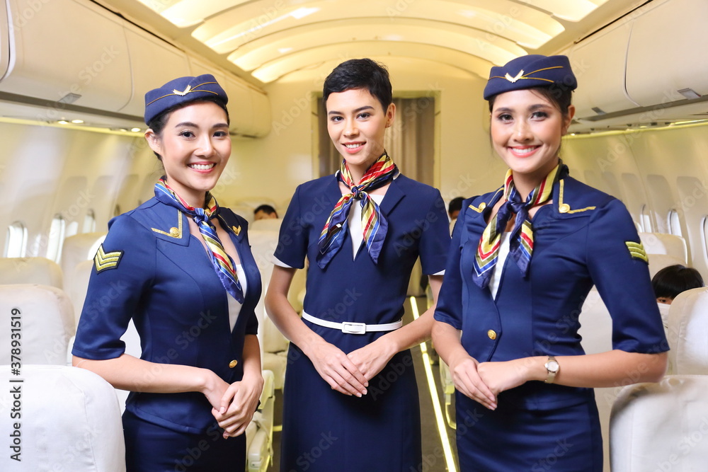 Team of diverse flight attendant posing with smile at middle of the ...