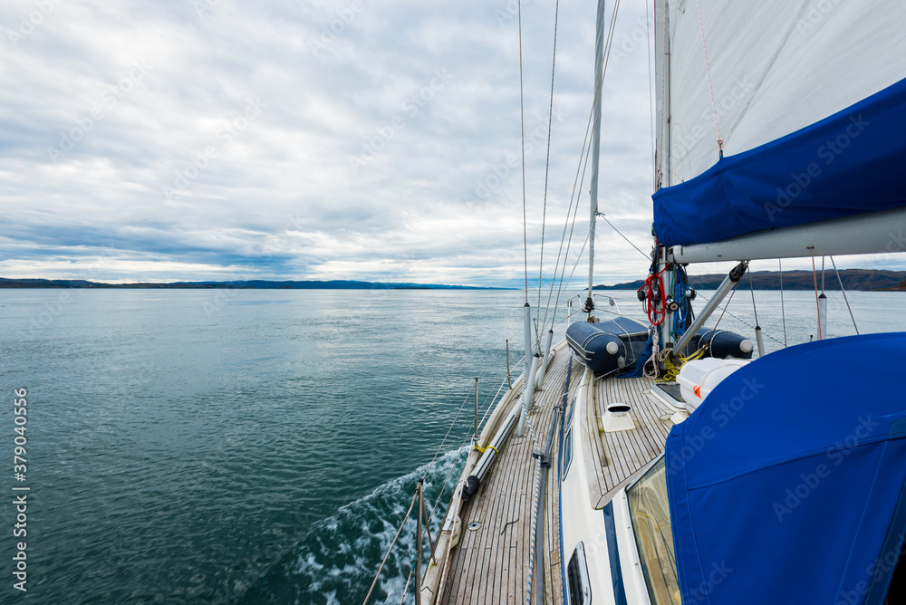 Fotka „Sloop rigged modern yacht with wooden teak deck sailing near the ...