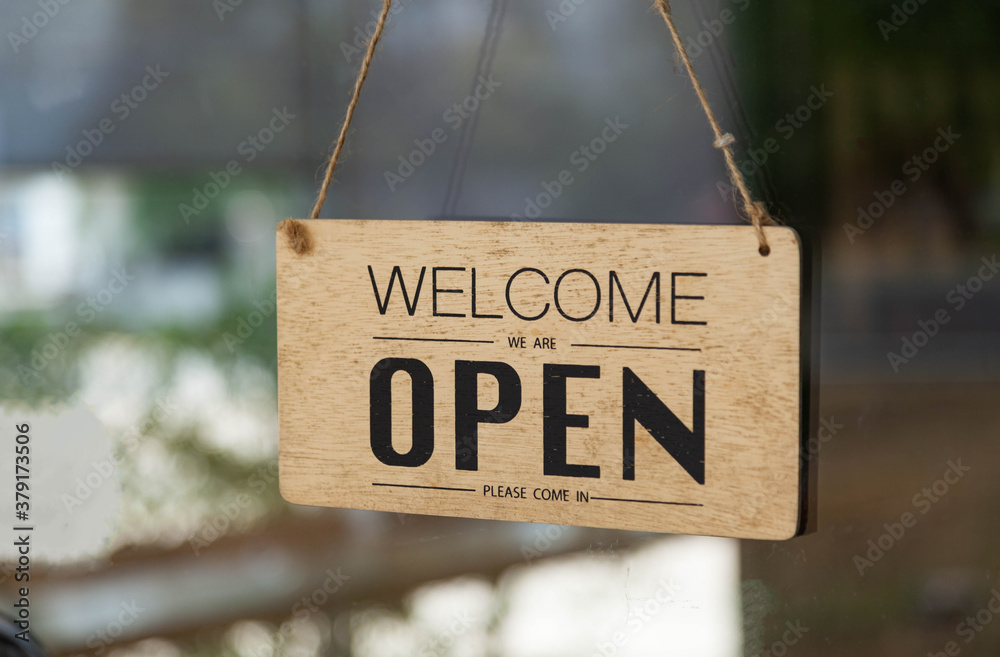 Open sign broad through the glass of door in cafe with colorful bokeh ...