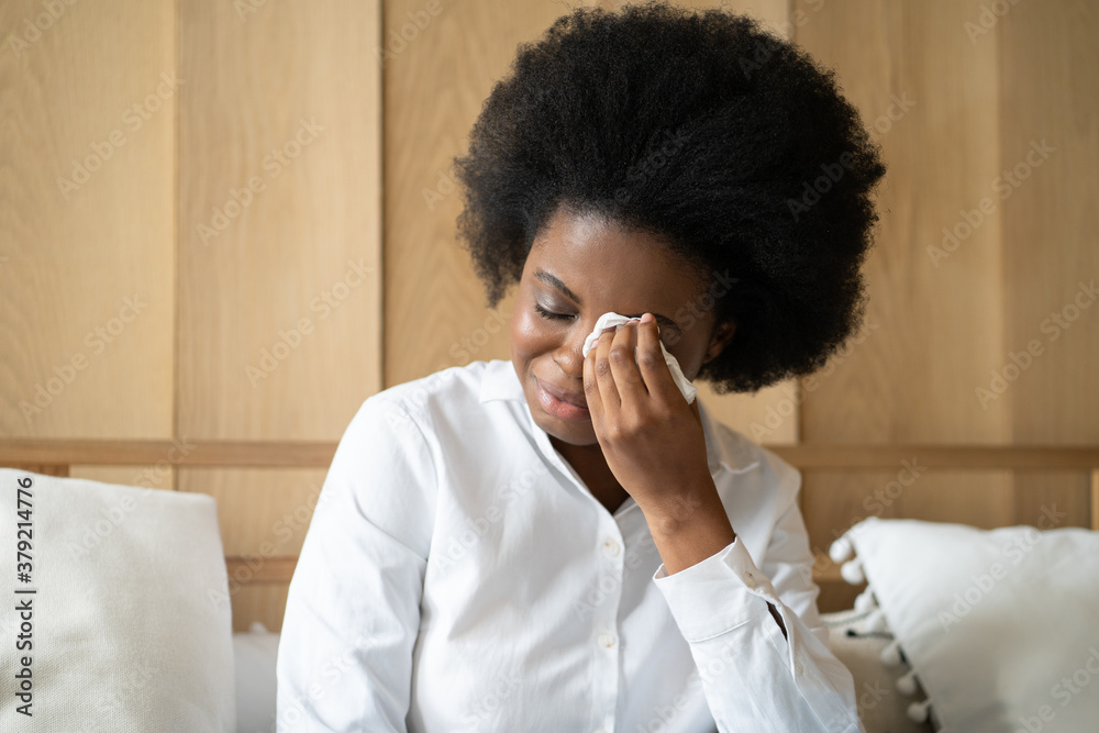 Unhappy depressed Black woman crying and wiping tears with paper tissue ...