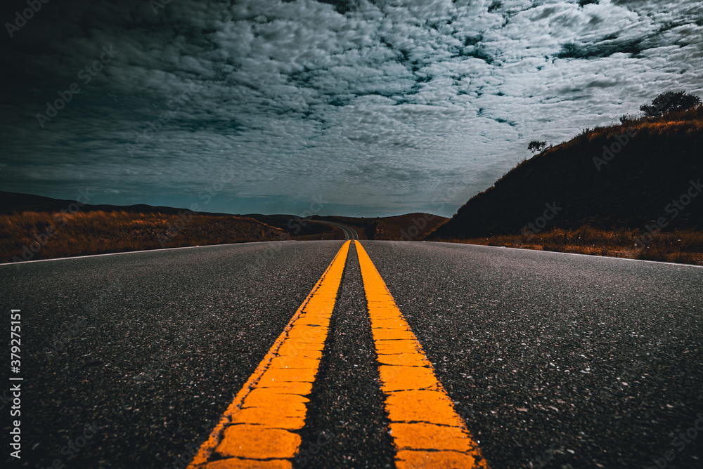 Perspective view of yellow lane lines of an old asphalt road through ...