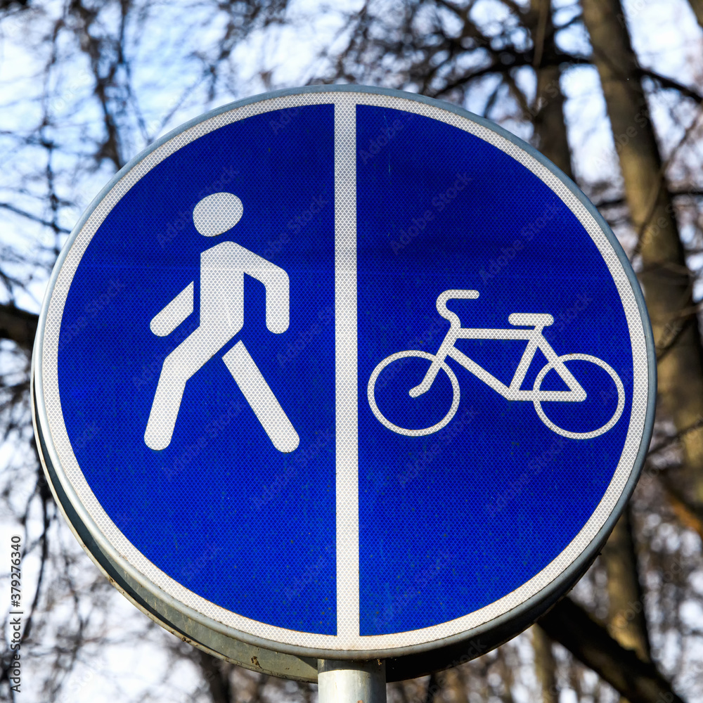 Round blue sign "Pedestrian and Bicycle path" close-up. A sign that ...