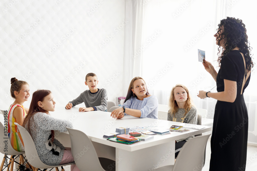 Teaching in a classroom. Young woman teacher teaching kids in ...