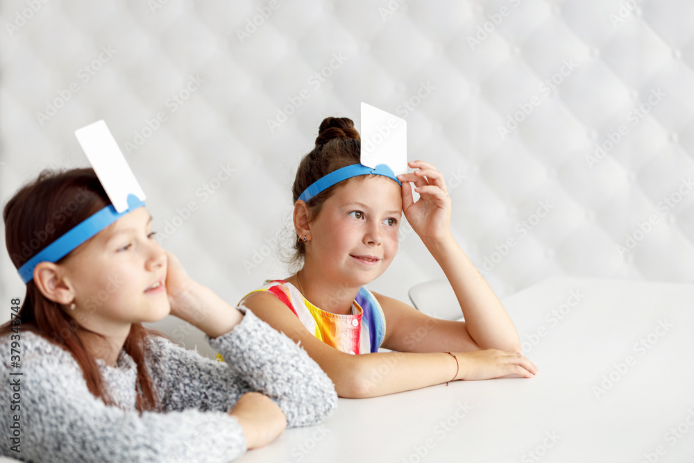 Girls Playing guess sticker. Children playing a game. Stock Photo ...