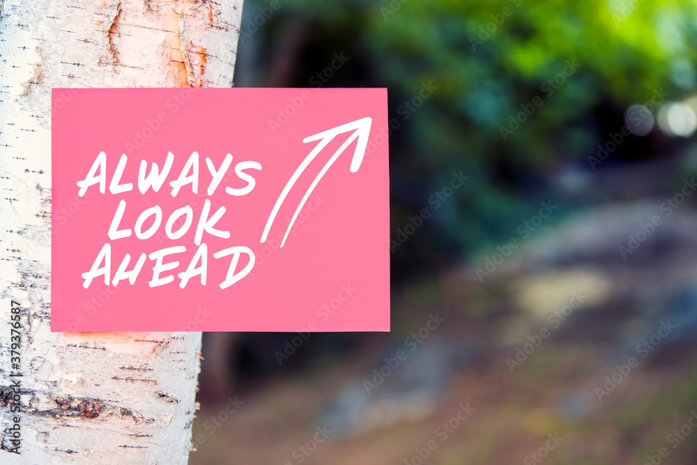 Always look ahead inspirational motivational quote written on a tree in nature. Leaving the past ...