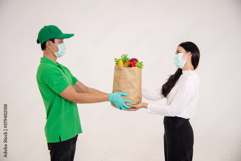 Lady recieving food ingredients from food delivery man with wearing ...