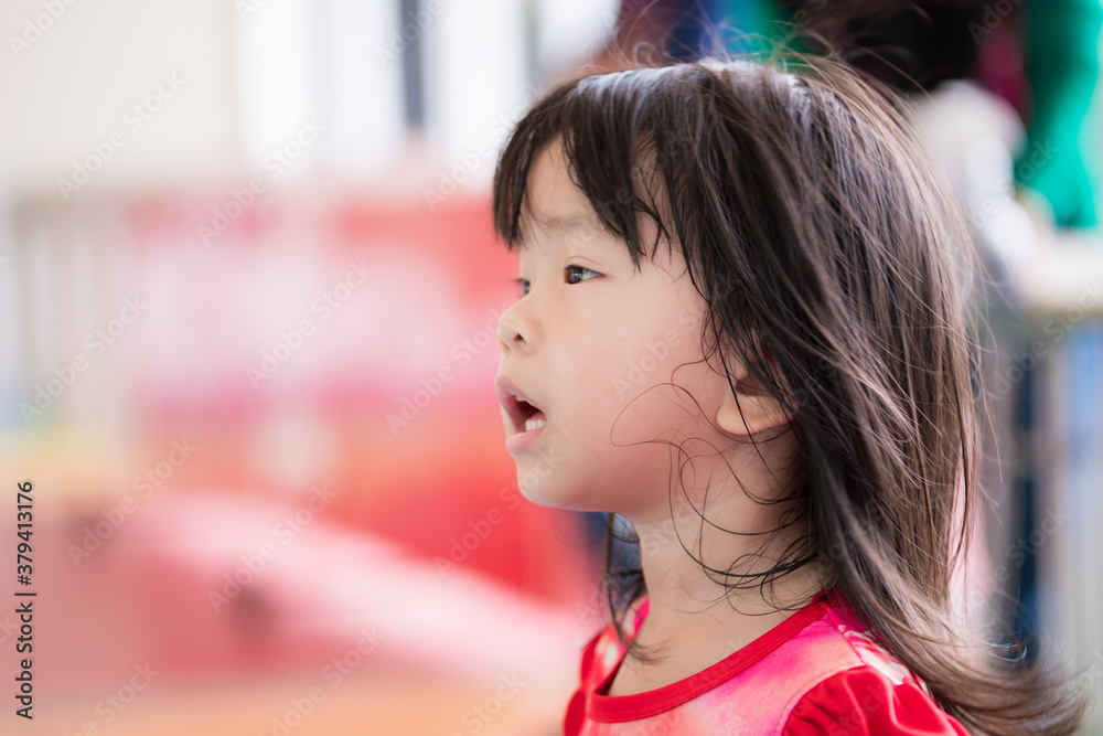 Side view of a cute Asian girl was shocked with a mouth open expression ...