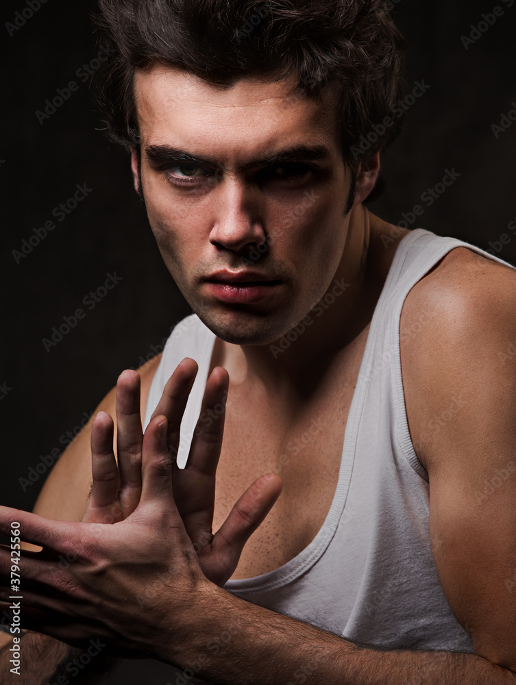 Sexy male model posing in white underwear in dark shadow background ...