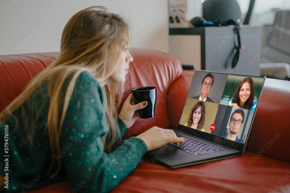 Back view of young woman talking to her colleagues about plan in video ...