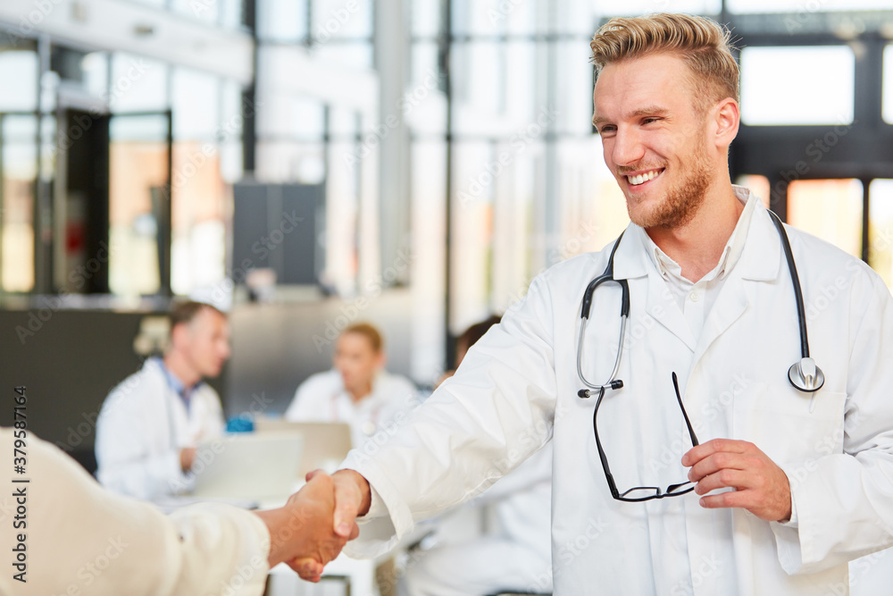 Man as a doctor in training during handshake Stock Photo | Adobe Stock