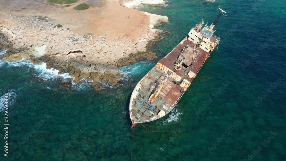 The sunken rusty ship has been lying on the rocks for many years. The ...