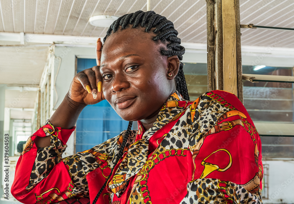 Africa woman with traditional strong colors sitting and waiting for the ...