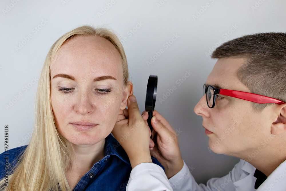 Darwin's tubercle on the ear. The girl at the reception at the plastic ...