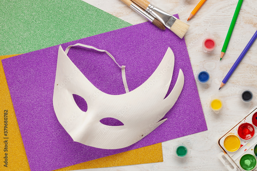 Paper Carnival mask and paints DIY on a white wooden background. Mardi ...