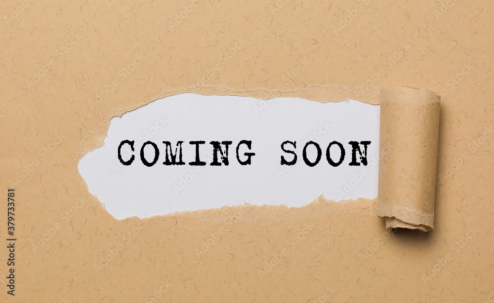 The text COMING SOON, appearing behind torn paper. The craft paper is ...