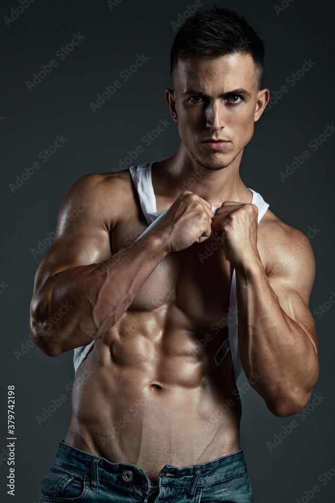 Male model with perfect body in white undershirt and jeans posing over ...