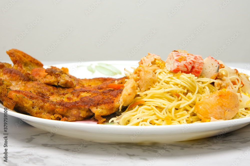 A picture of "mee raja" with chicken chop on the marble table. "Mee ...