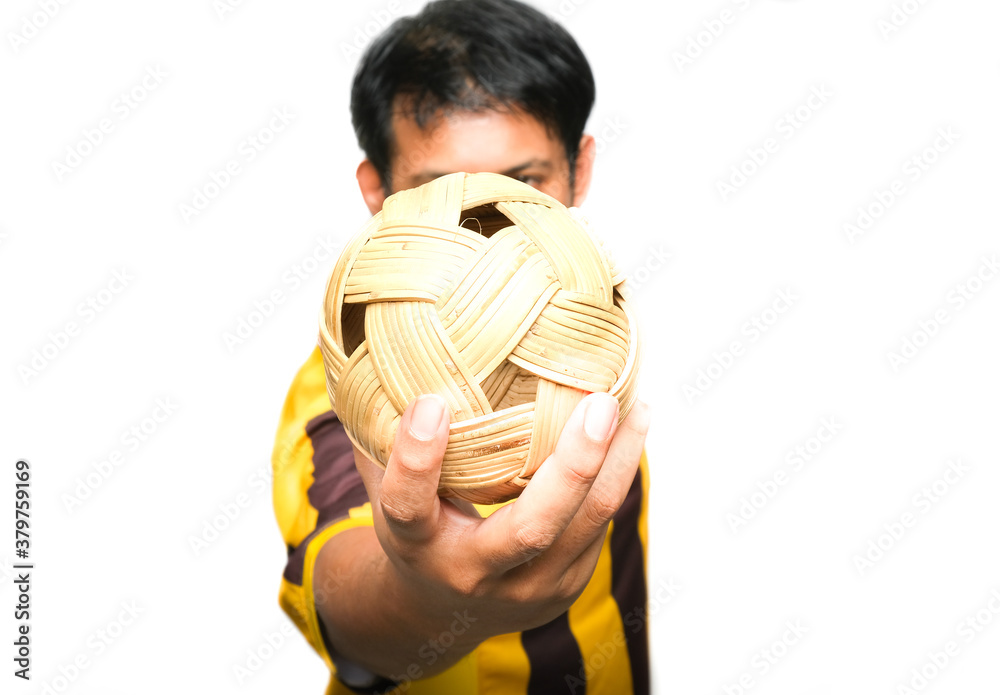 Selective focus of "takraw" been hold by a men on isolated white ...