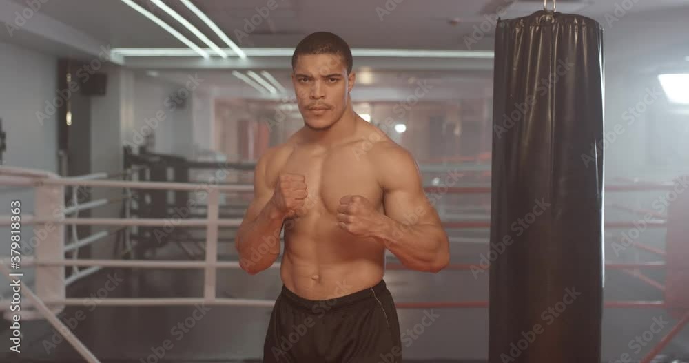 Boxing, athletic man fighter trains in boxing gym, a muscular man takes ...