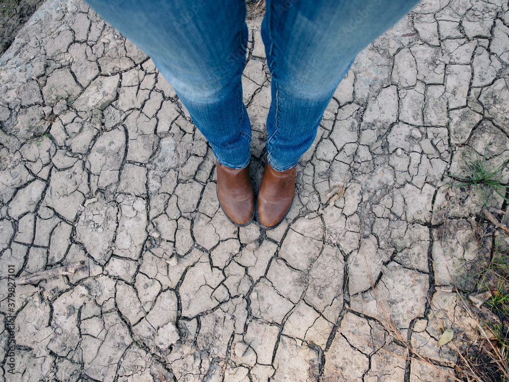 Young woman in jeans and leather boots standing on cracked earth Stock ...