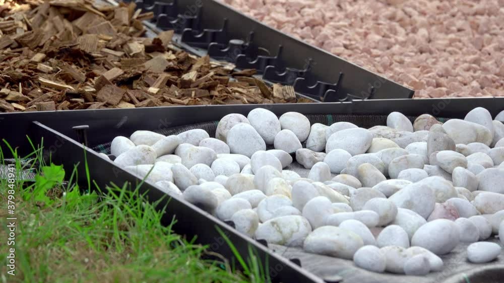 Young children constructing a path, in the sensory garden, made of ...
