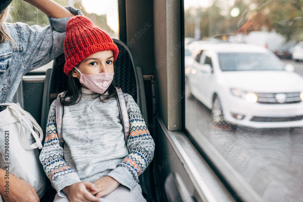Image of the kid wears a red winter hat in protective face mask going ...