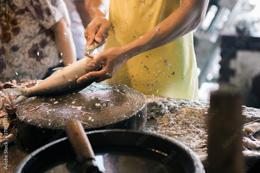 Fishmonger Deboning and Descaling Milkfish or Bangus in a Market in the ...