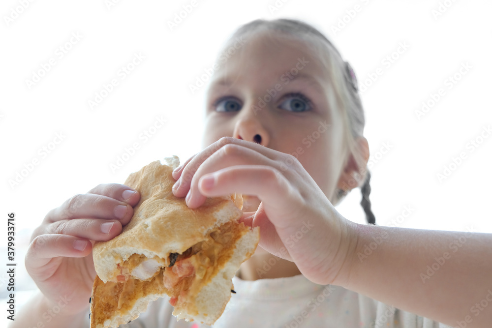 Little girl eating hamburger in a fast food restaurant. Child having ...