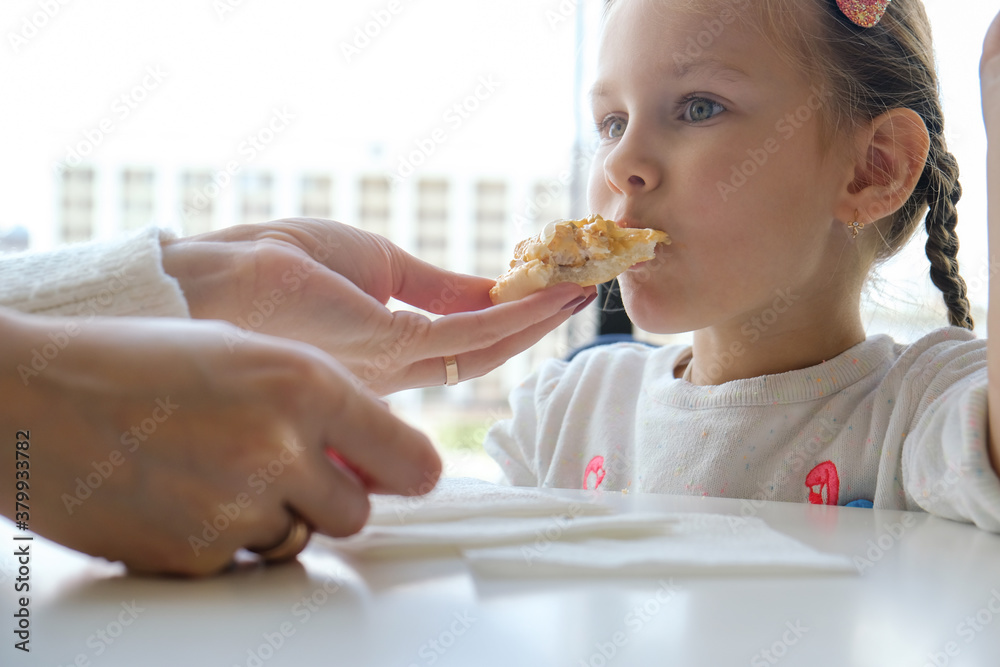 Little girl eating hamburger in a fast food restaurant. Child having ...