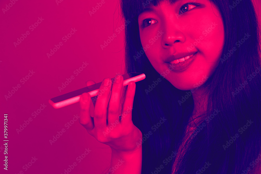 Recording voice. Close up portrait of asian woman isolated on studio ...
