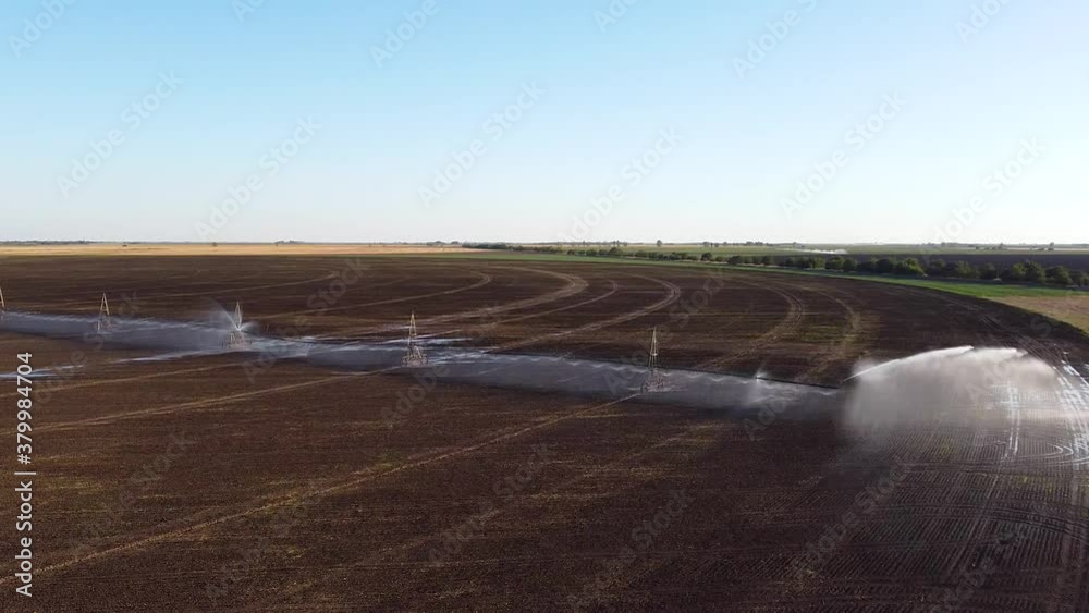 Drone footage of an irrigation system works at the field with sprinkler ...