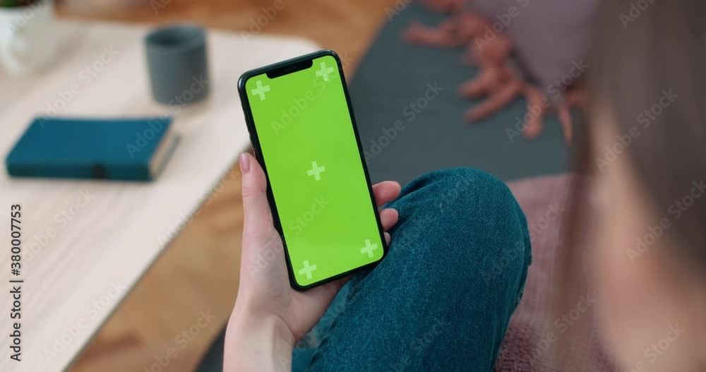 Backside view of woman holding and looking at smartphone mock up screen ...