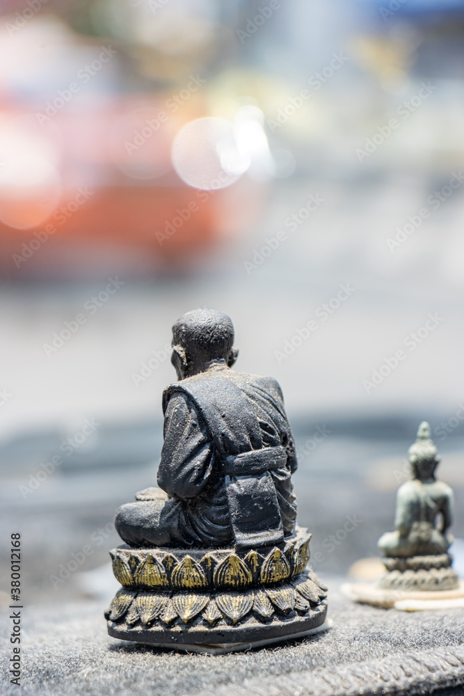 Small religious figurines on the dashboard of a moving car. Figurine of ...