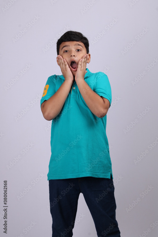 happy young child enjoying making a funny face, sticking out his tongue ...