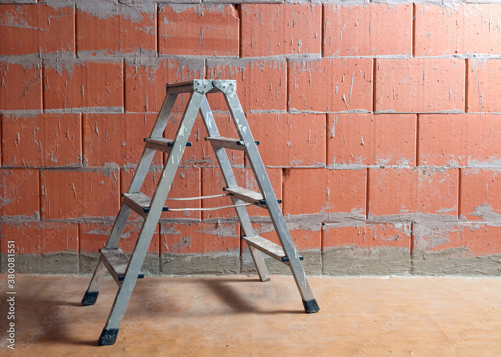 Small step ladder in front of a raw brick wall from Porotherm style ...