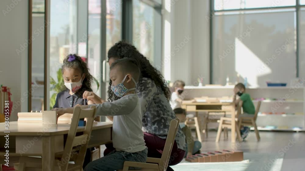 Pandemic learning. Teacher runs a lesson in a socially distanced school ...