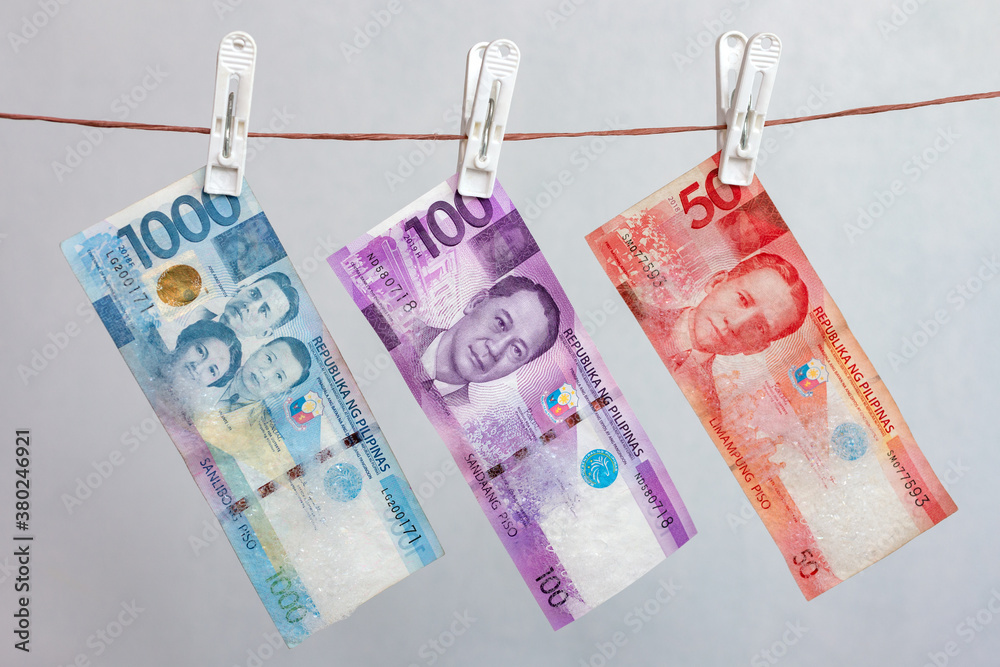 Three banknotes in nominee of 50, 100 and 1000 Philippines peso hanging ...