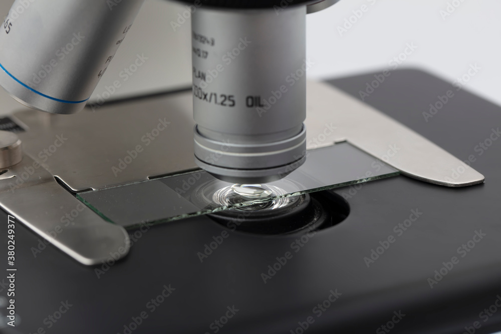 Examining of test sample under the microscope in laboratory. Optical ...
